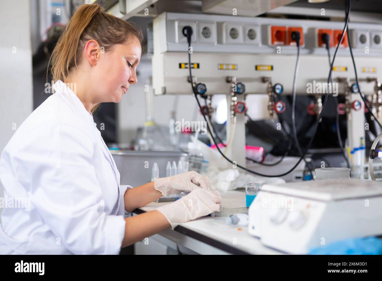 Female pharmacist researcher waiting for color change in test tube ...
