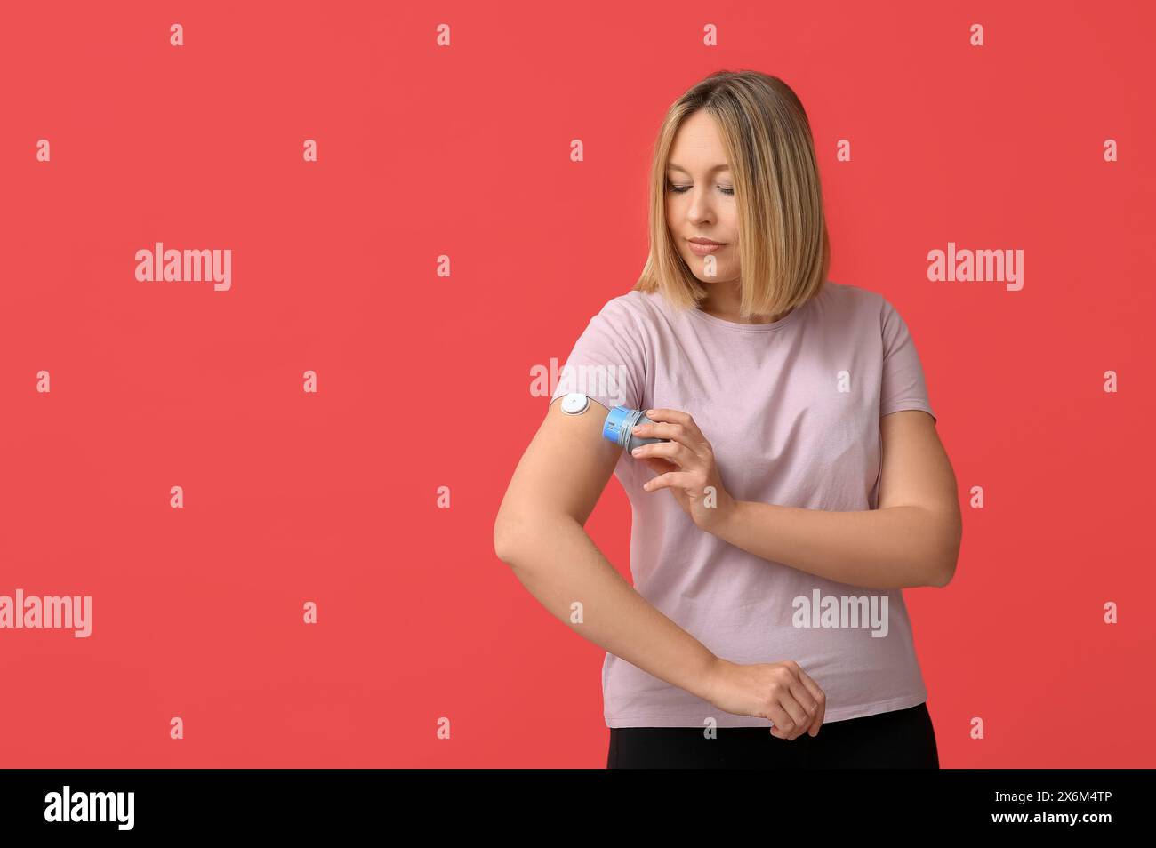 Woman with glucose sensor for measuring blood sugar level and ...