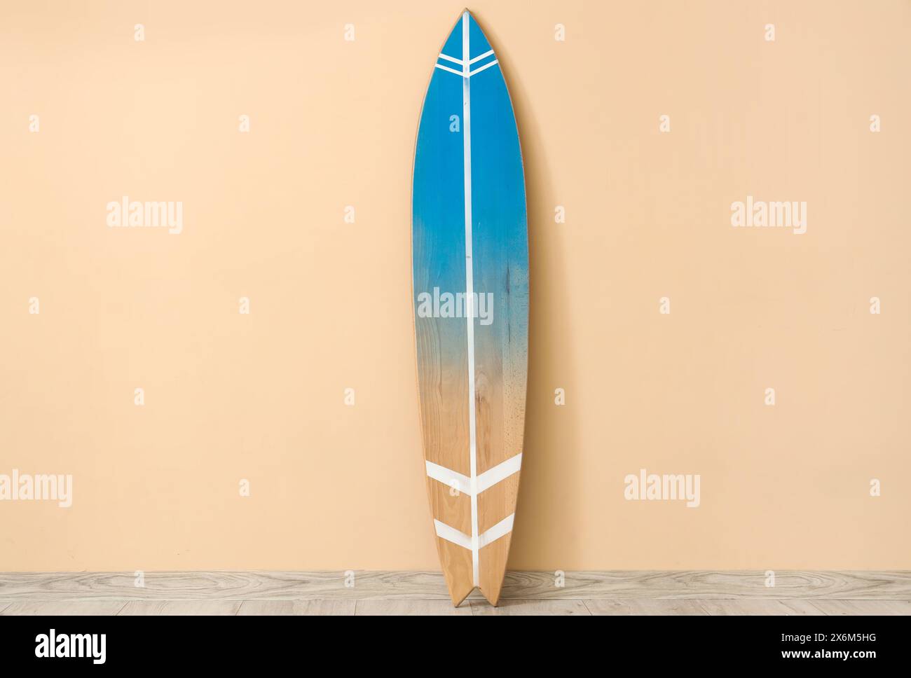 Wooden surfboard near beige wall Stock Photo - Alamy