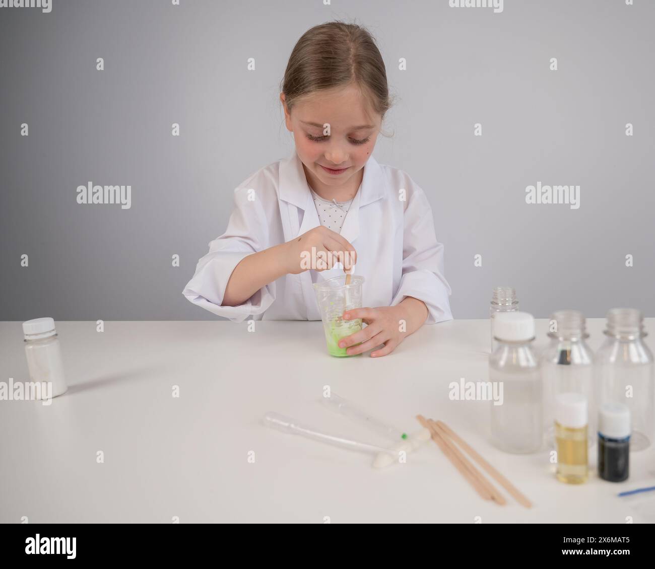 Caucasian girl doing chemical experiments on a white background. Making ...