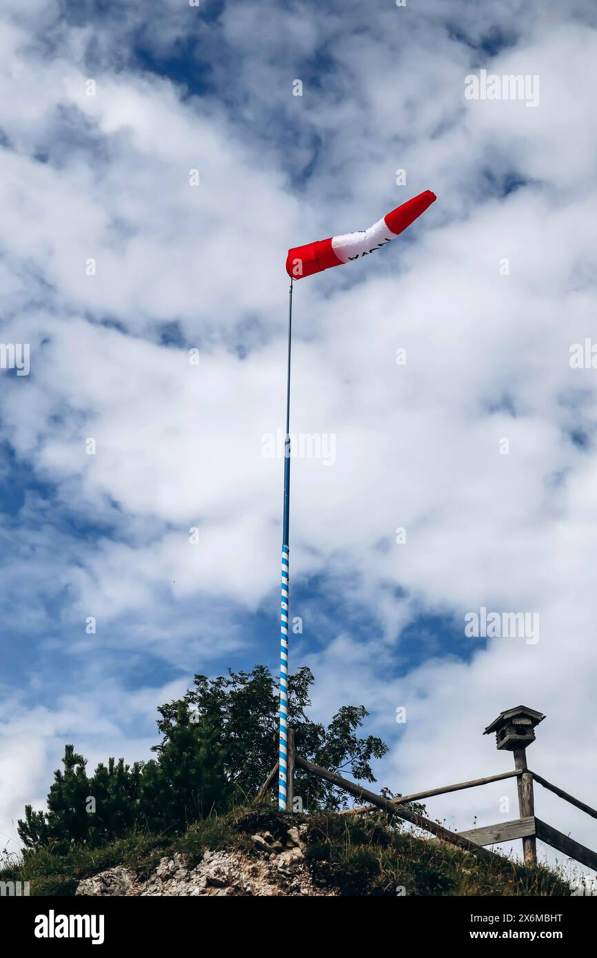 Red and white wind indicator cone with blue sky and clouds in the ...