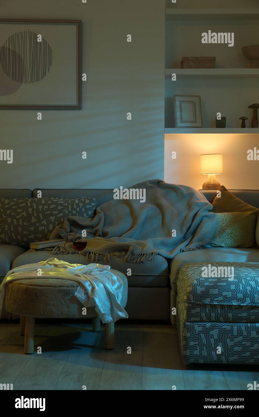 Stylish room interior with couch and lamp at night Stock Photo - Alamy