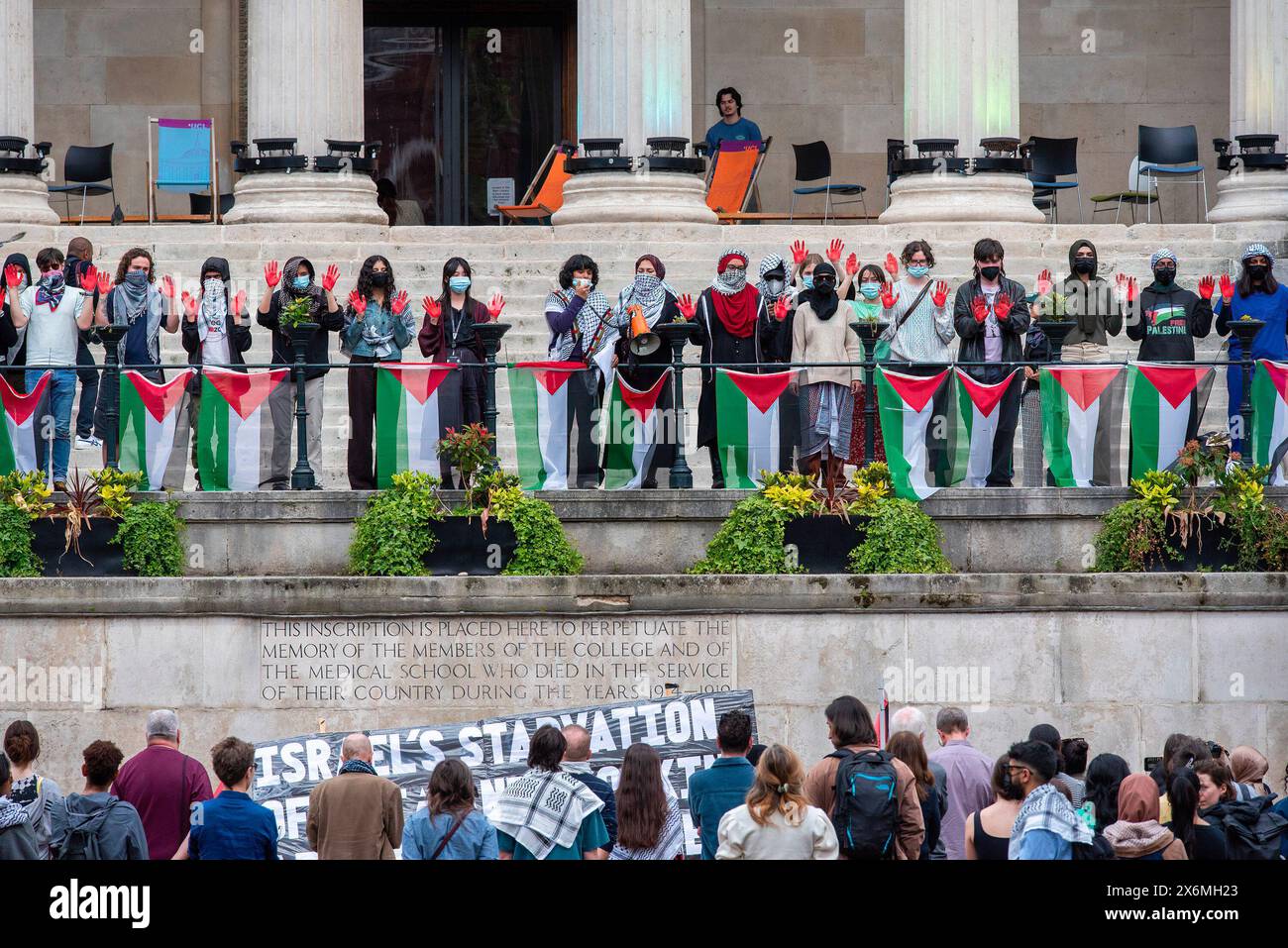 Students hold up their hands, covered with red paint referring to the ...