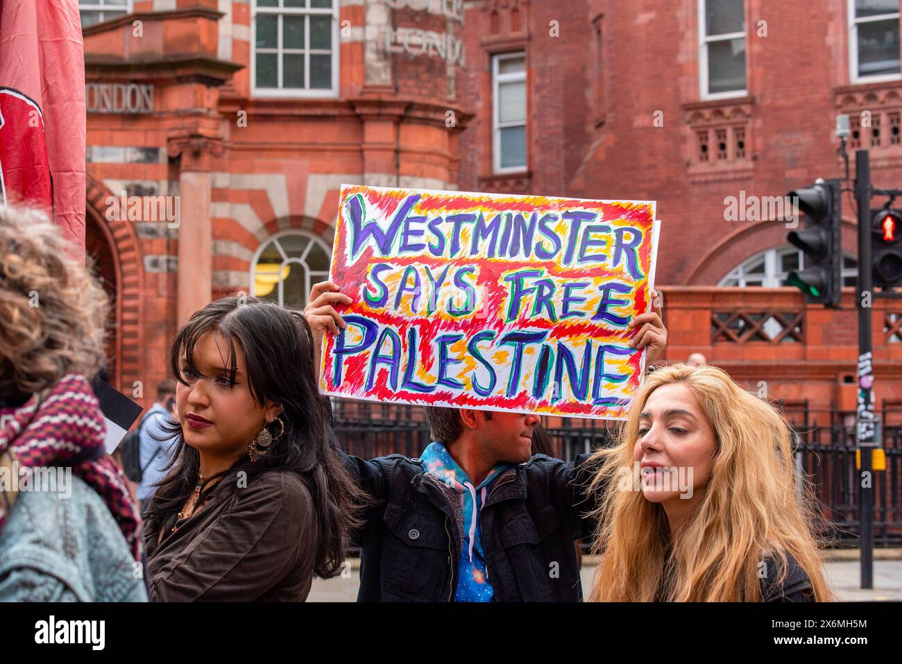 A protester holds a placard outside the gate of the University College ...