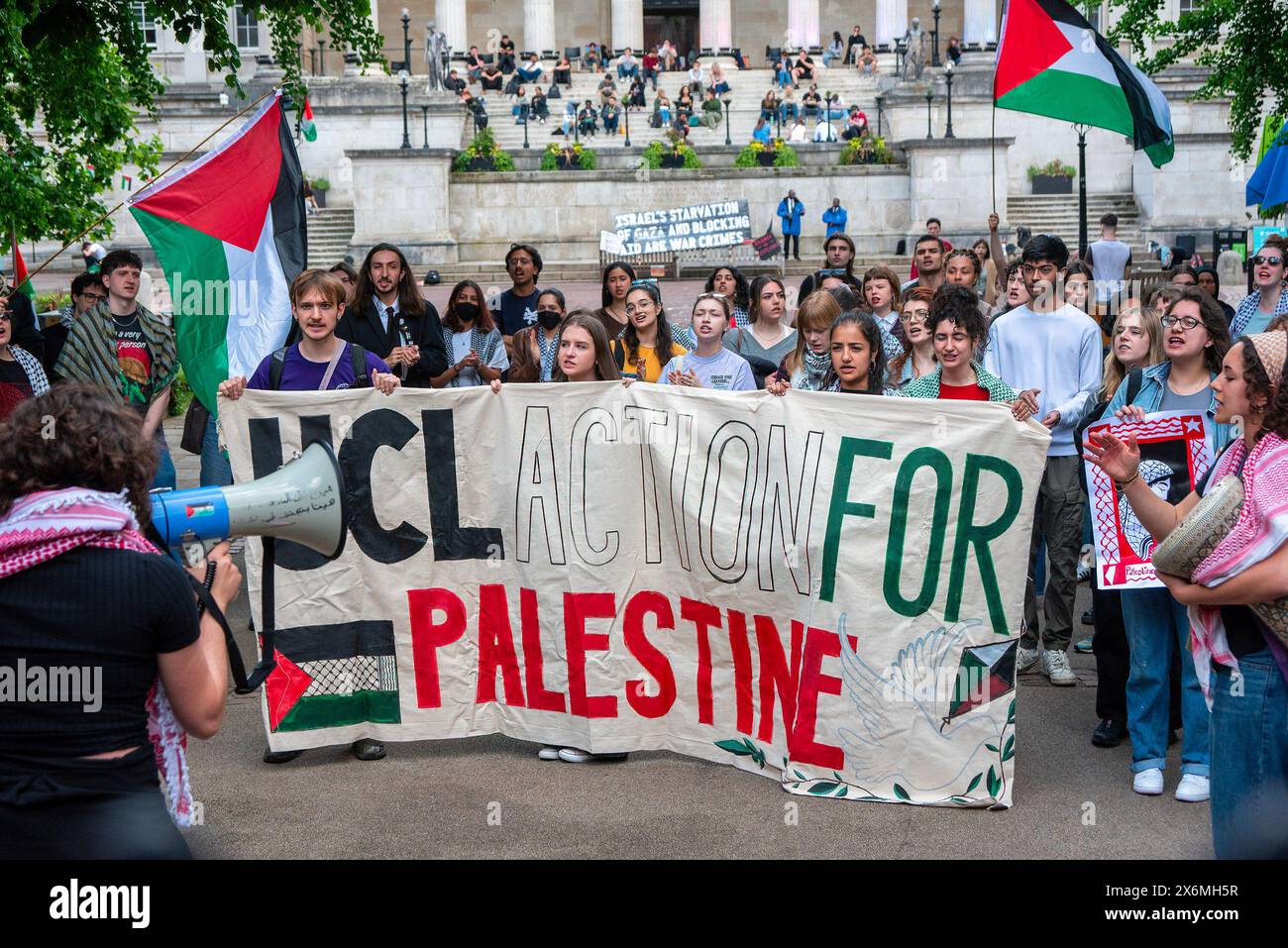 Students hold a banner and shout slogans inside the University College ...