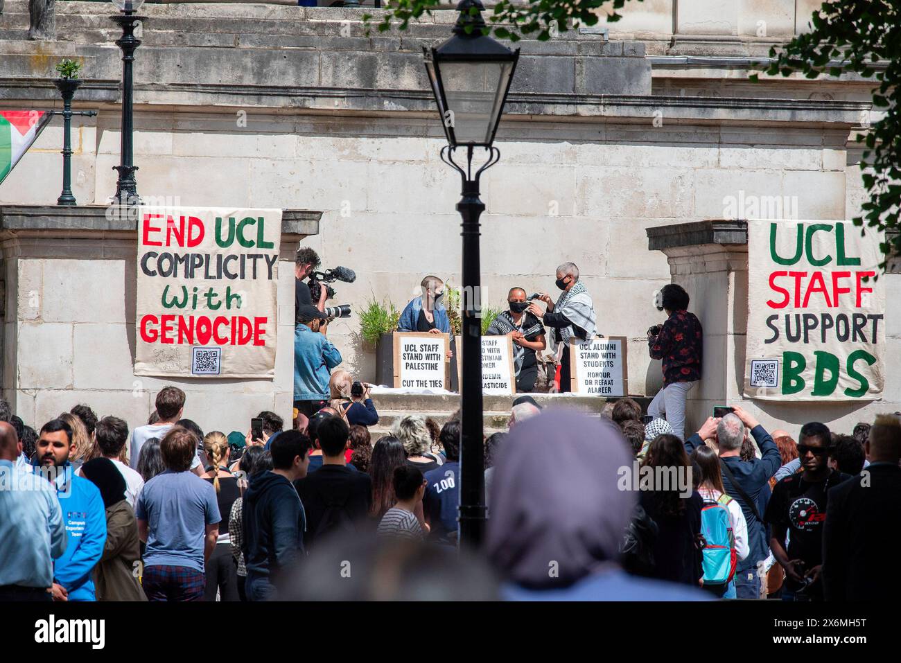 One of the female UCL staff cuts the hair of the other member of the ...
