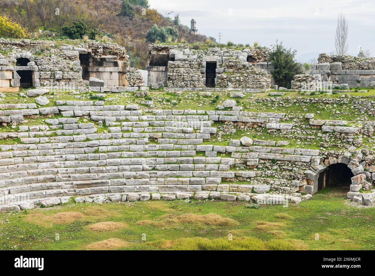 Stone seating rows in ancient amphitheater, surrounded by greenery ...