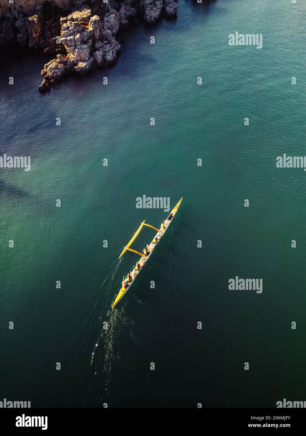 Aerial perspective captures a yellow canoe paddled by a group of people ...