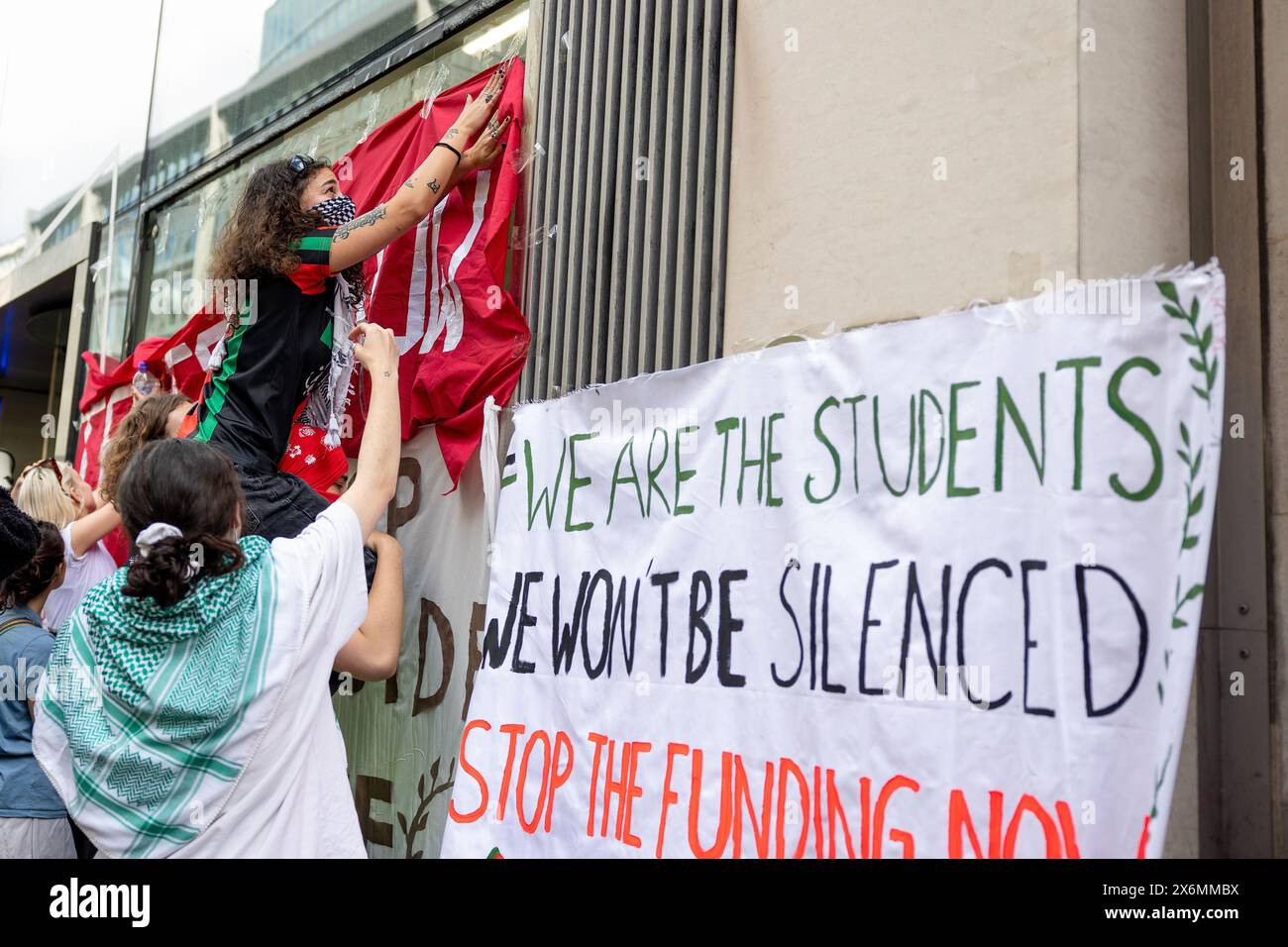Students are seen putting a banner outside the Holborn campus of UAL ...