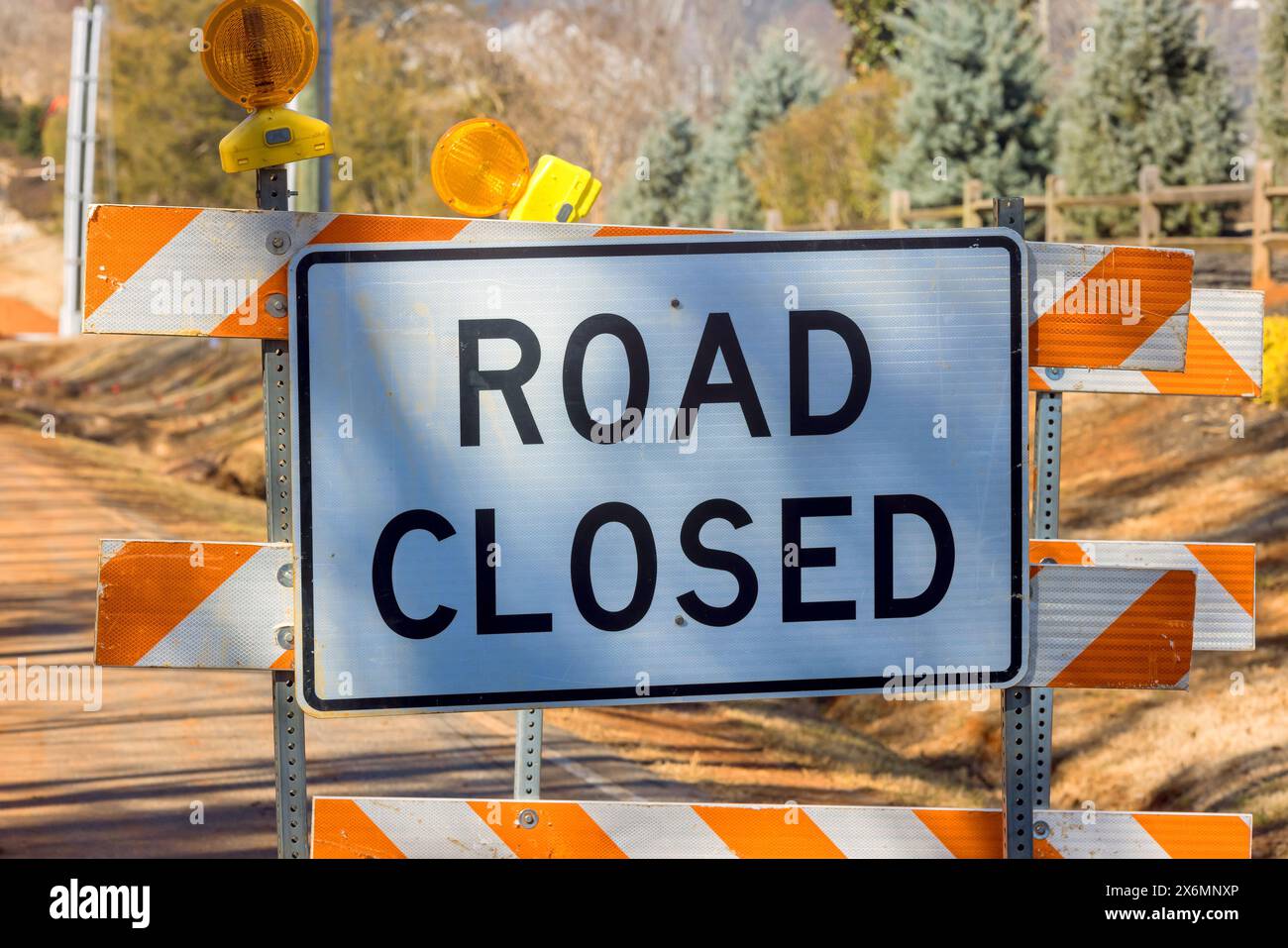 There is orange striped road closure sign near an ongoing construction ...