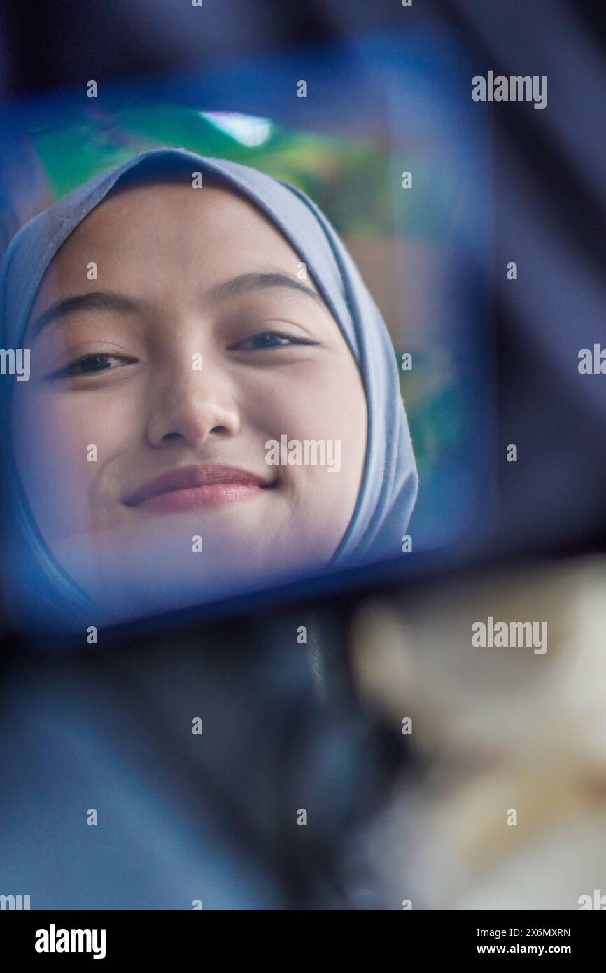 asian woman seen from small mirror with happy facial expression Stock ...