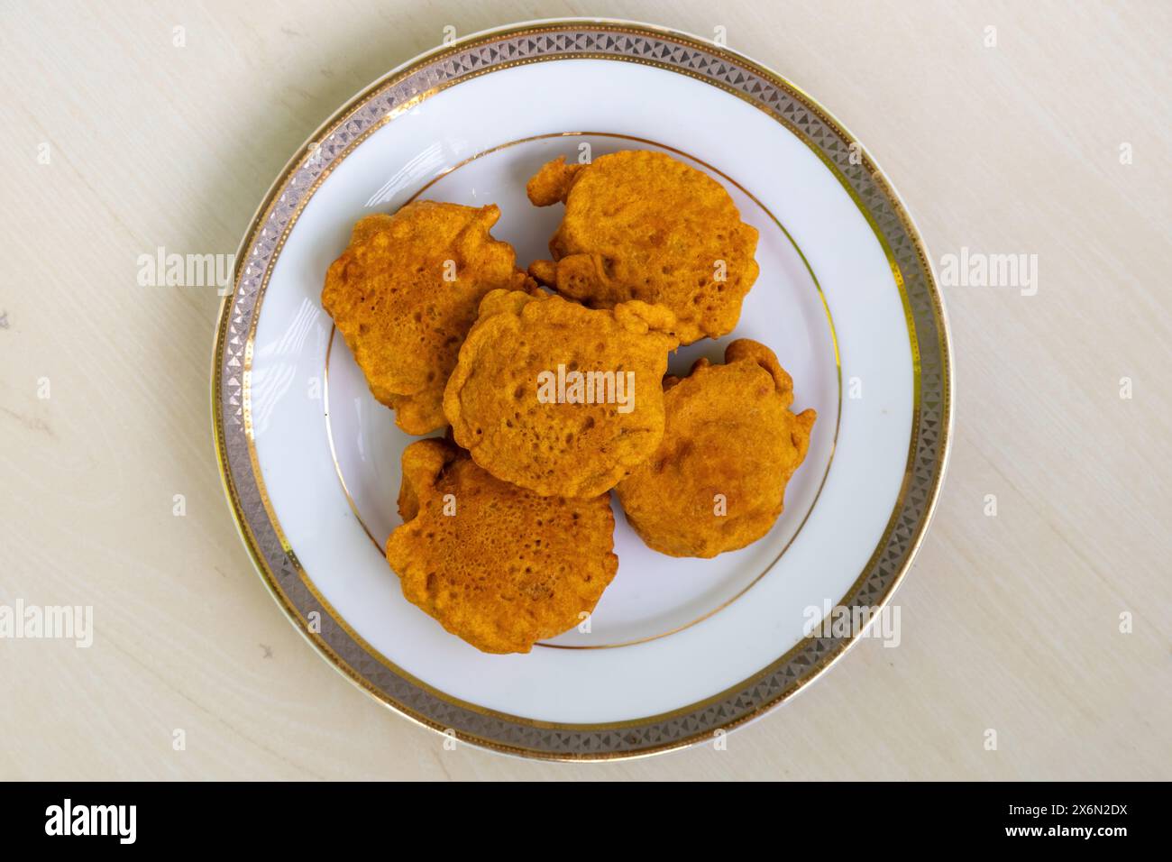Delicious homemade Aloo Chop on a white plate on wooden background. Alu ...