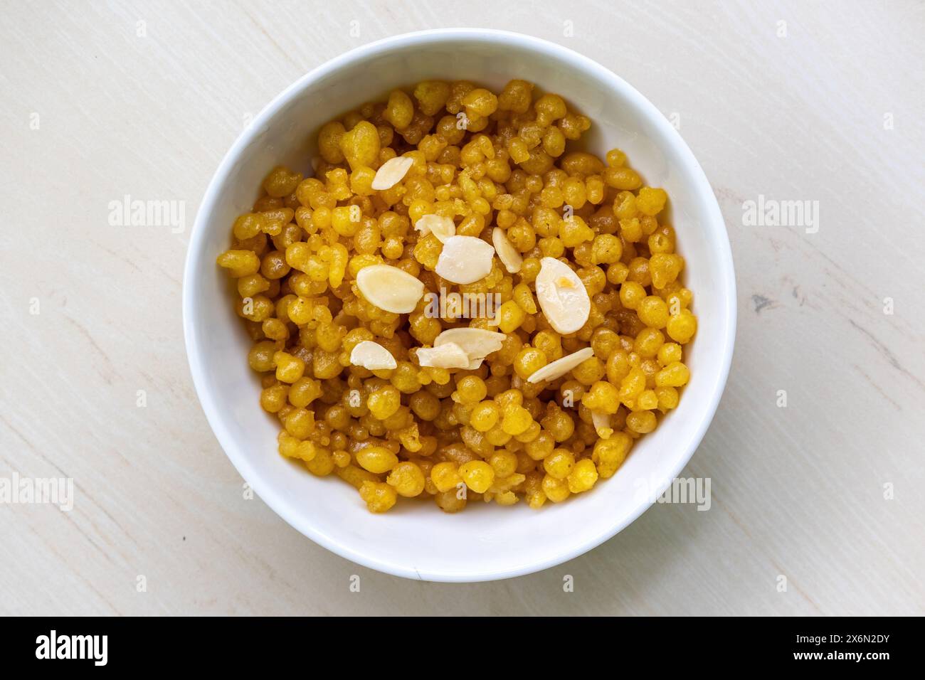 Traditional tiny sweet Bundiya on a white bowl on wooden background. It ...