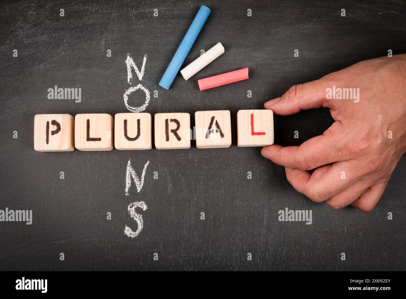 Plural nouns. Wooden block crossword puzzle and pieces of chalk on a ...