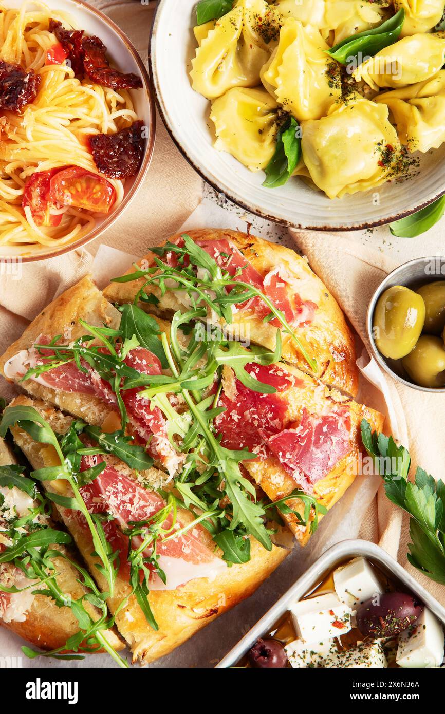 Full table of italian meals on plates pizza, pasta, ravioli, salad and ...