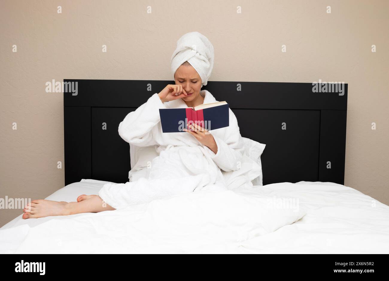 Woman In Her 30s Sits In Bed And Crying Reading A Book. Emotional ...