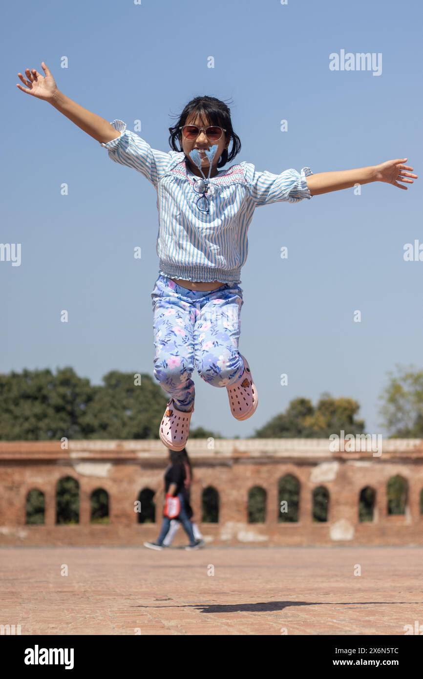 A pretty Indian girl child jumps in the air in happiness outdoor Stock ...