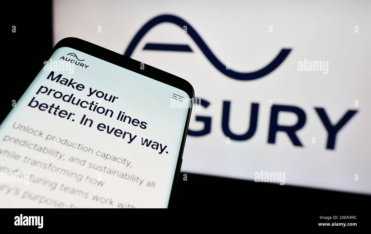 Mobile phone with website of Israeli technology company Augury Ltd. in front of business logo ...