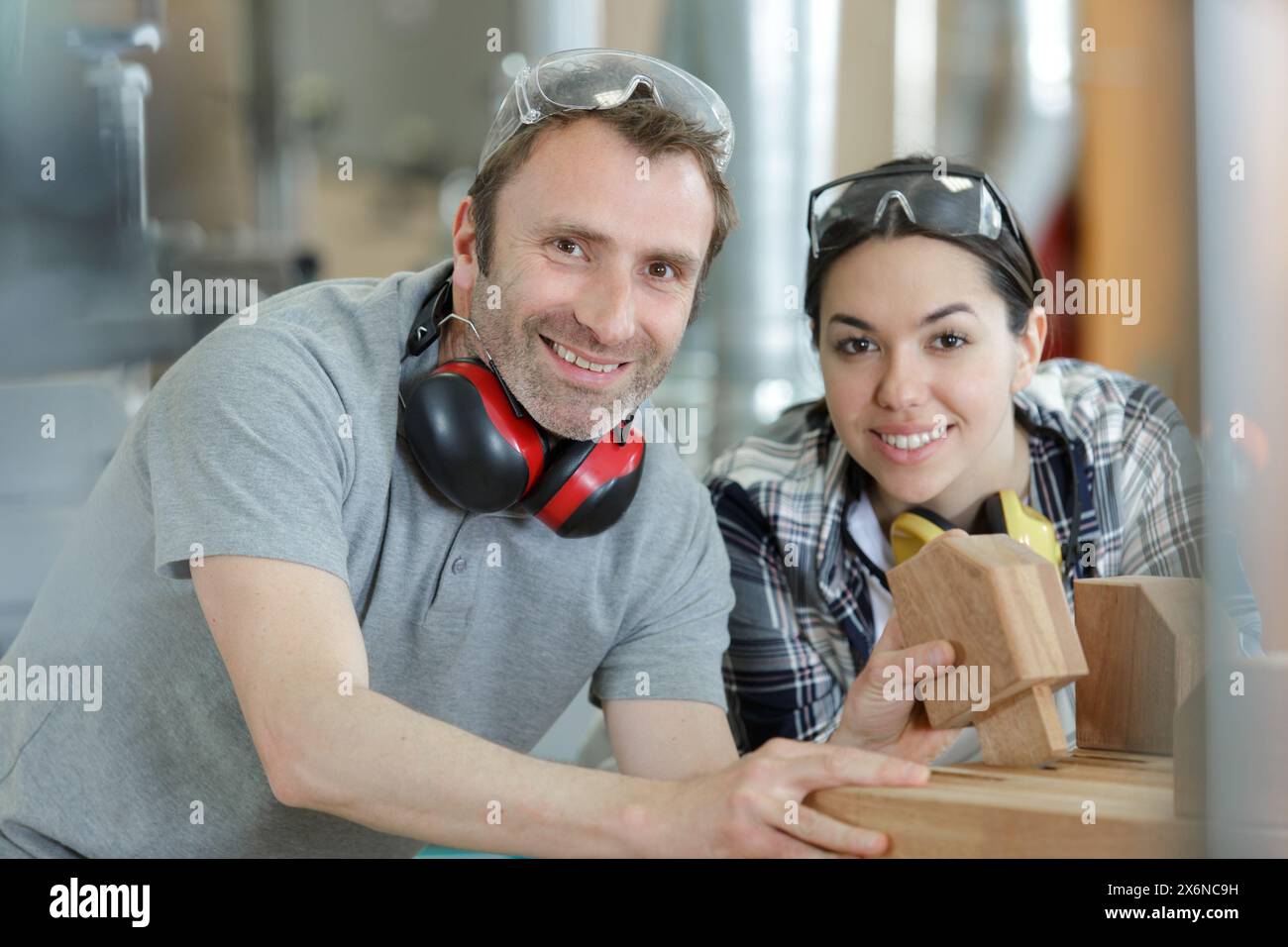 carpenter training female apprentice to use mechanized saw Stock Photo ...