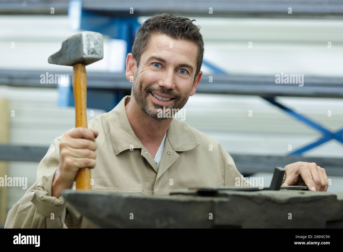 man using a hammer in factory Stock Photo - Alamy