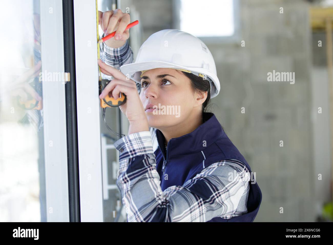 female builder looking at windows Stock Photo - Alamy