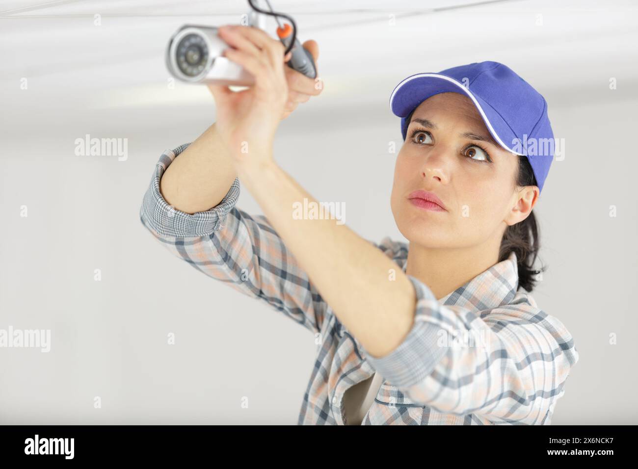 female cctv installer checking security camera Stock Photo - Alamy