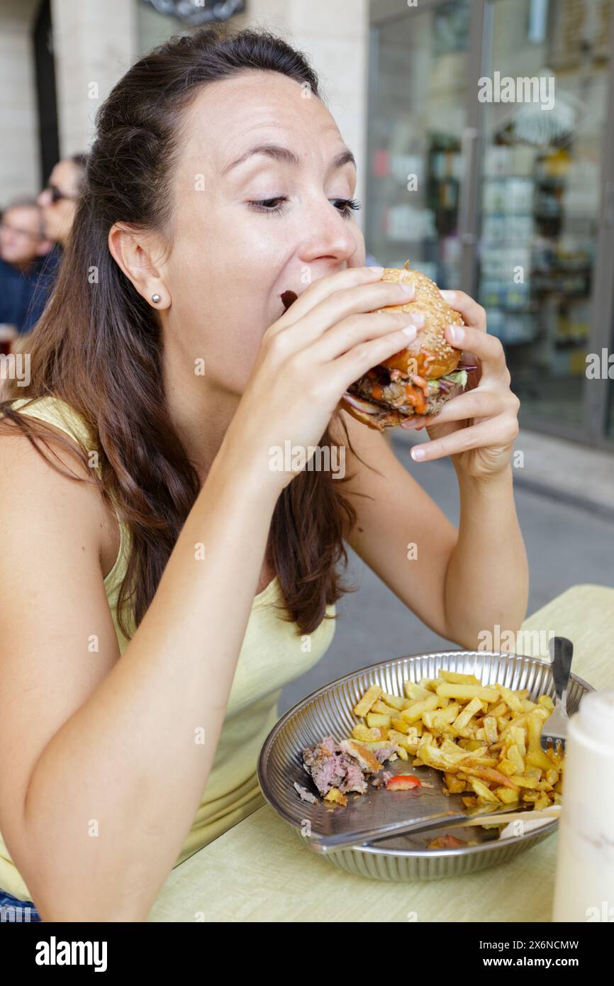 Brunette burger outdoor eating young hi-res stock photography and ...