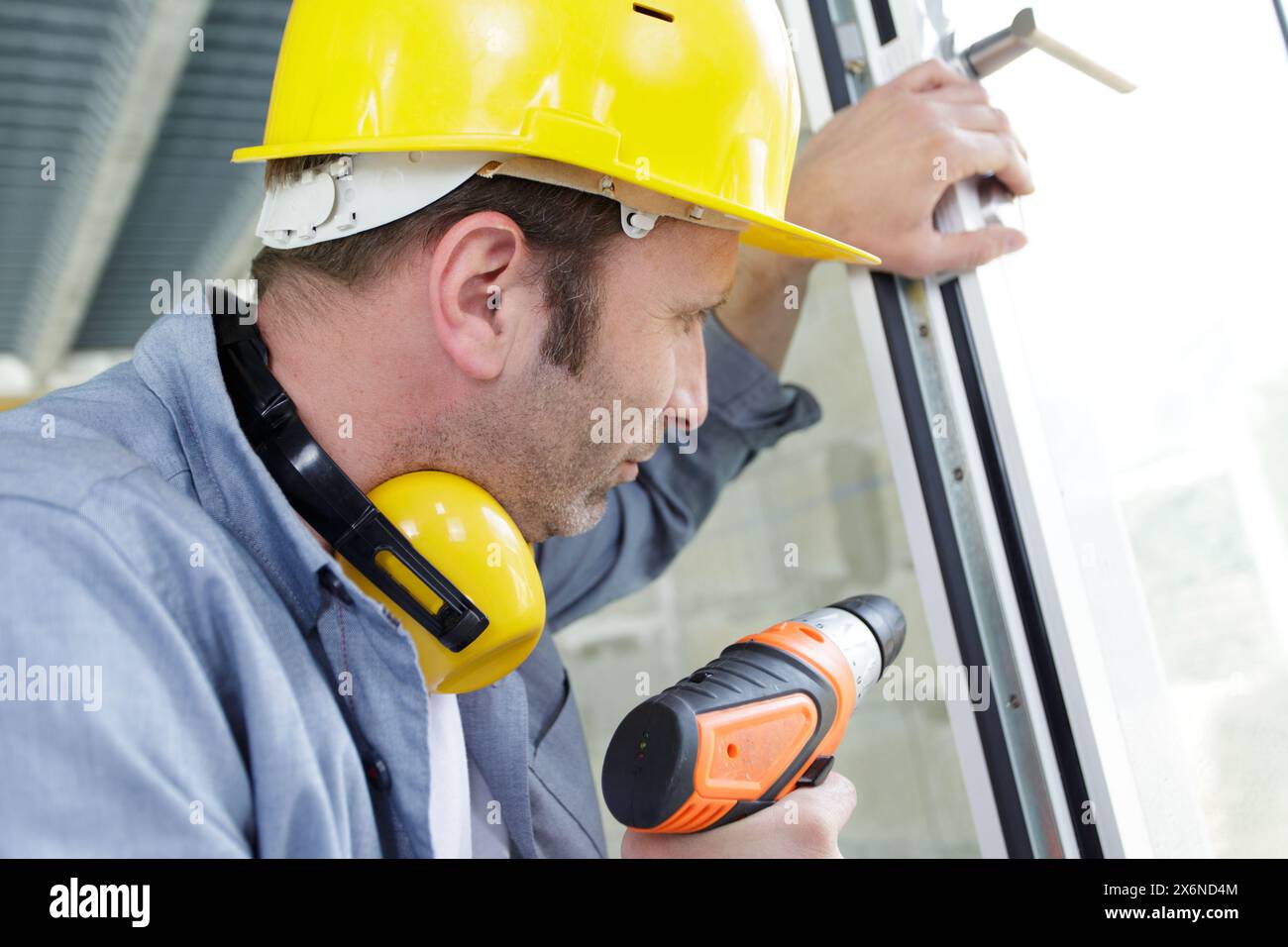 man drilling the window with impact drill Stock Photo - Alamy