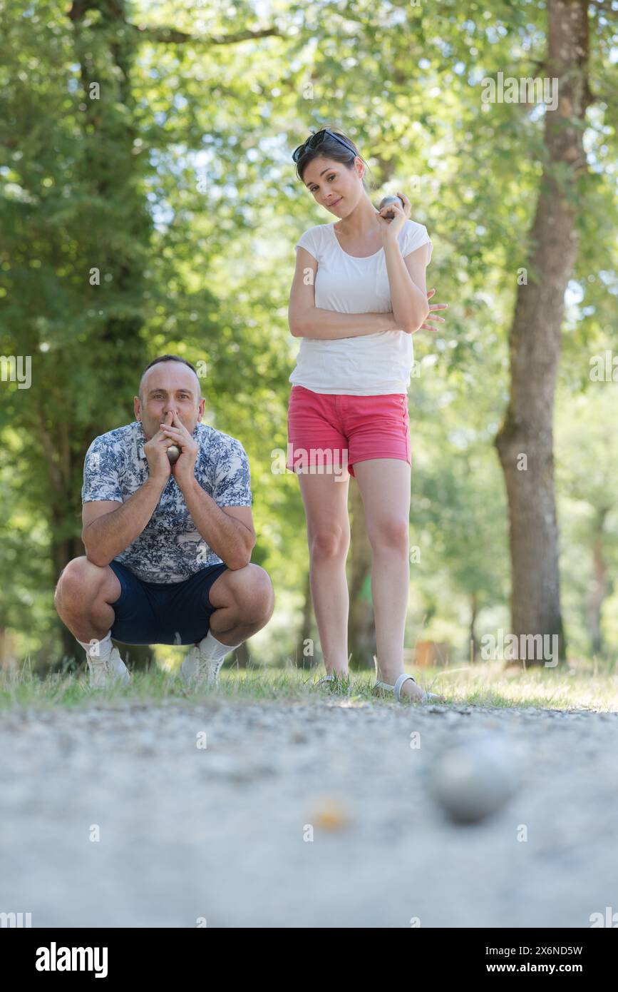 middle aged couple playing petanque woman looking coy Stock Photo - Alamy