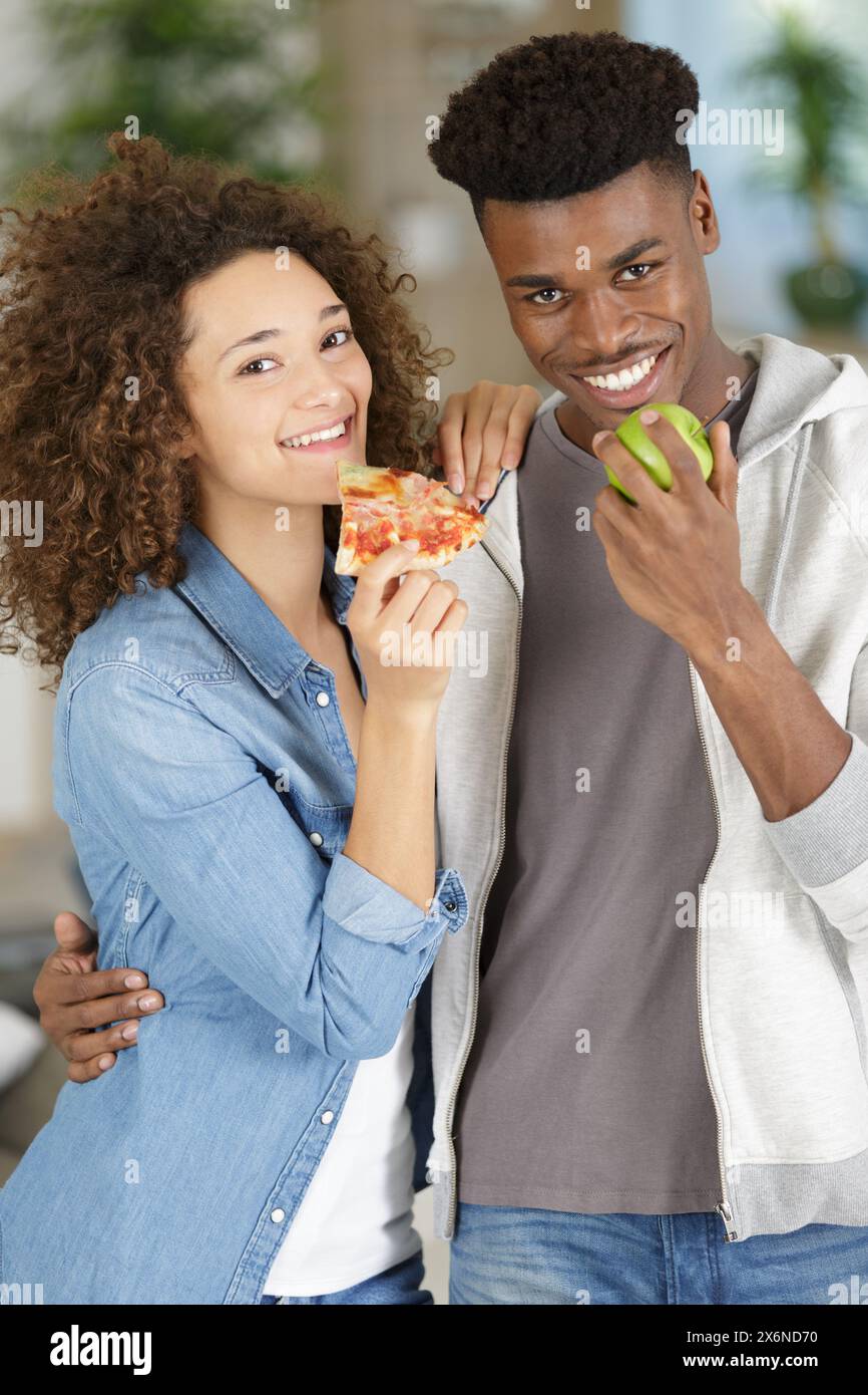 girlfriend eating pizza and boyfriend eating apple Stock Photo - Alamy