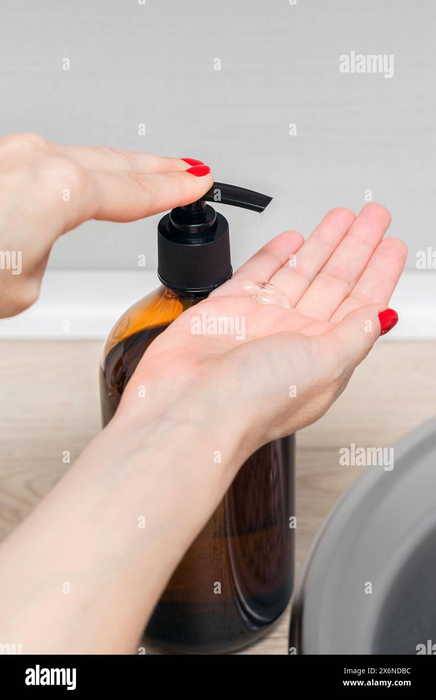 housewife using liquid soap dispenser in the kitchen. bottle of liquid ...