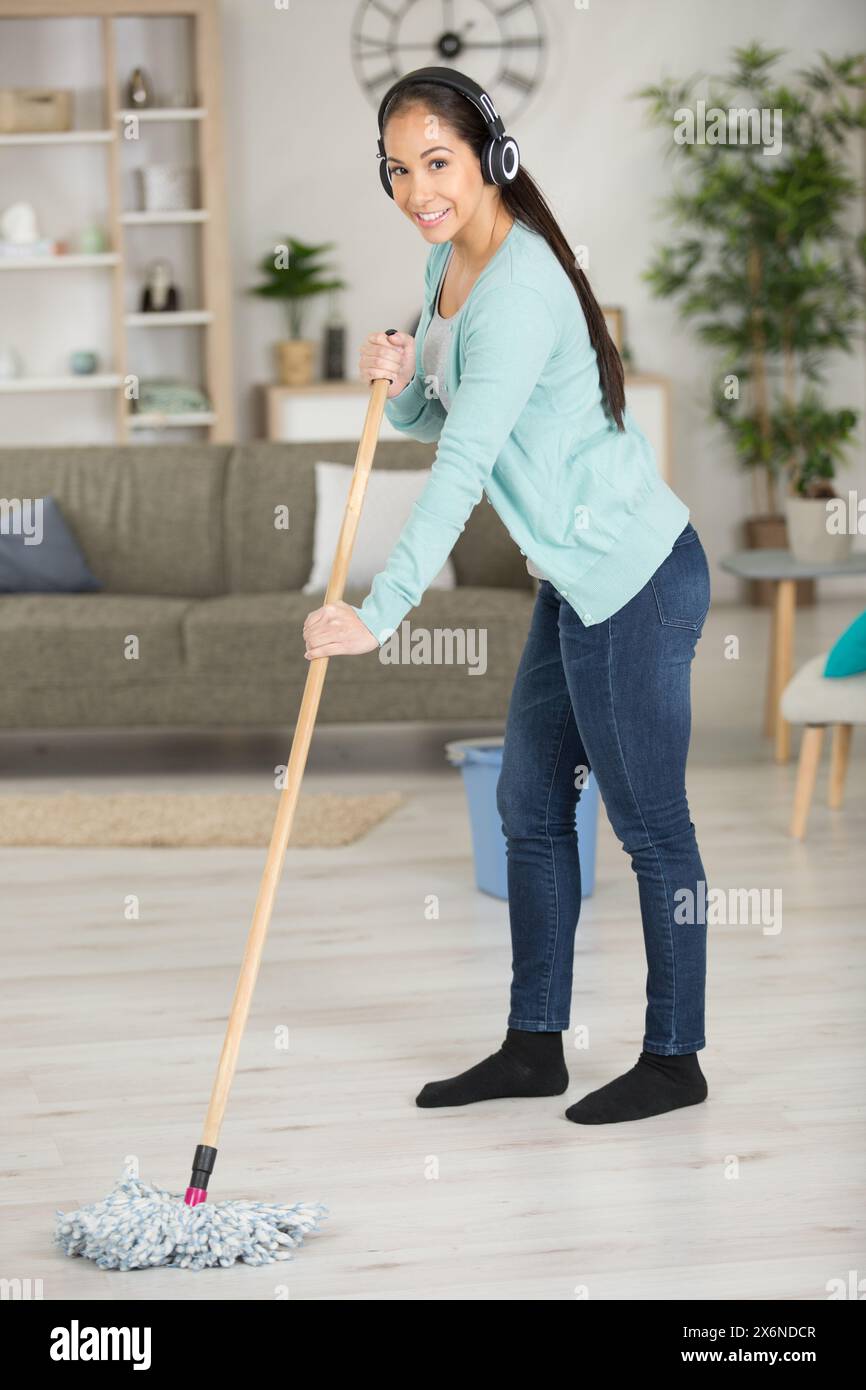 happy woman cleaning home dancing with mop and having fun Stock Photo ...