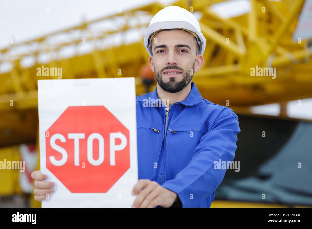 builder in a helmet showing stop sign Stock Photo - Alamy