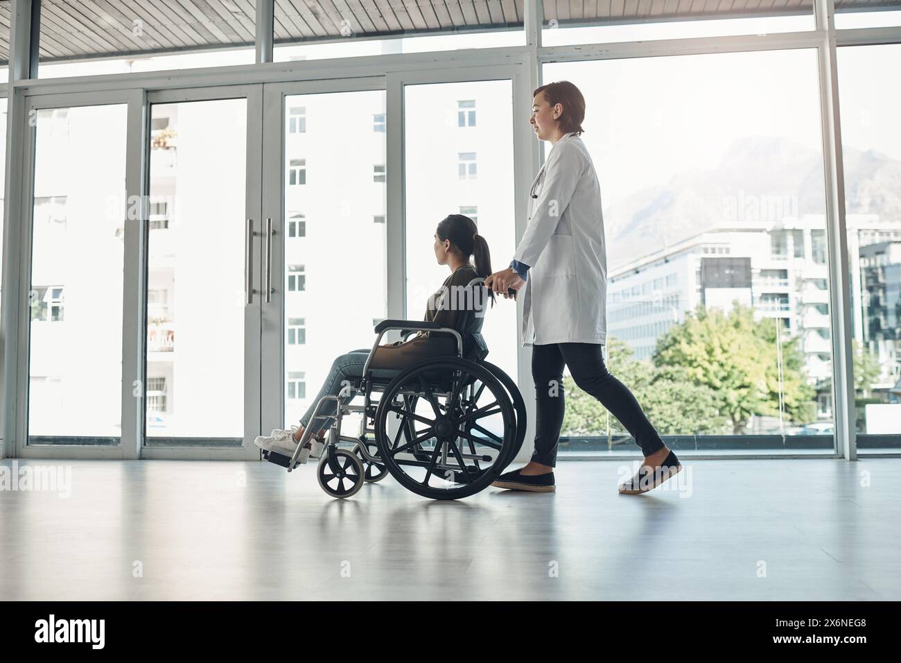 Wheelchair, doctor and walking with patient with disability in hospital ...