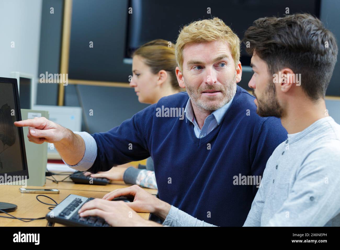 teacher helping student in computer class Stock Photo - Alamy
