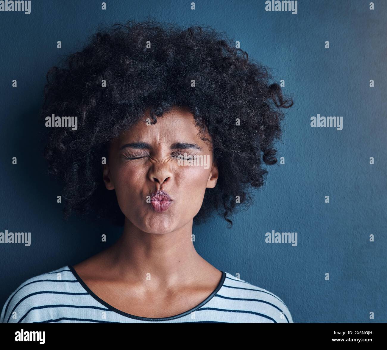 Black woman, emoji and kissing with funny face in studio for fun, relax ...