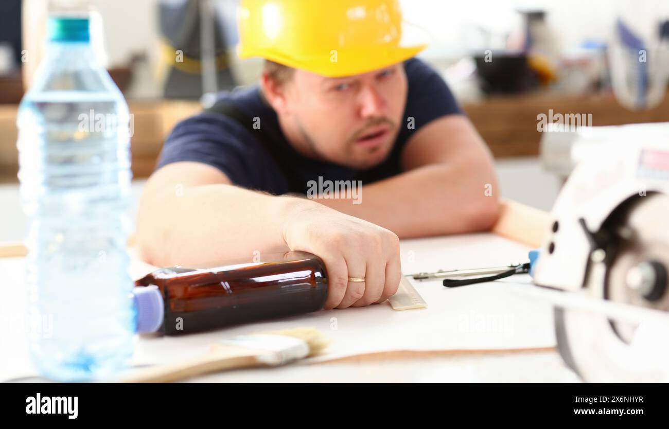 Arm of drunken worker in yellow helmet hold liquor Stock Photo - Alamy