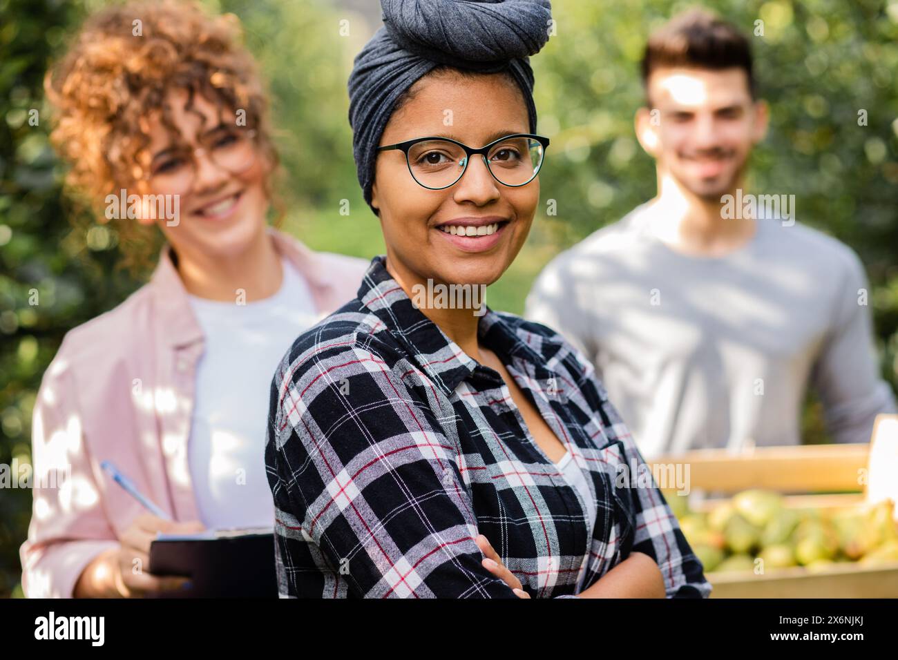 Portrait of three young farmers in pears orchard Stock Photo - Alamy