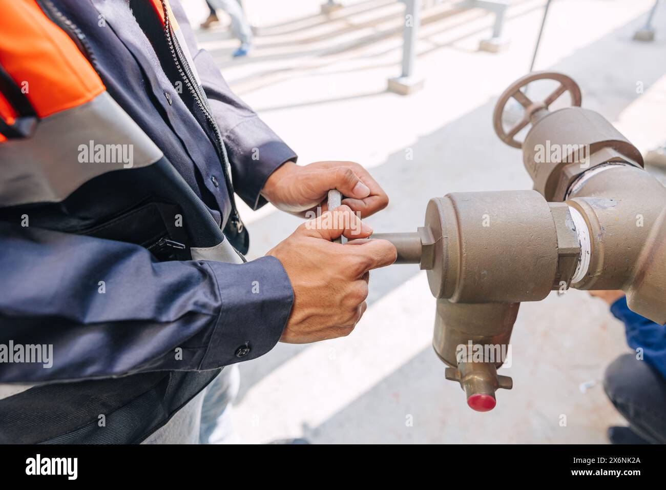engineer man wearing a safety vest is working on a pipe valve to turn ...