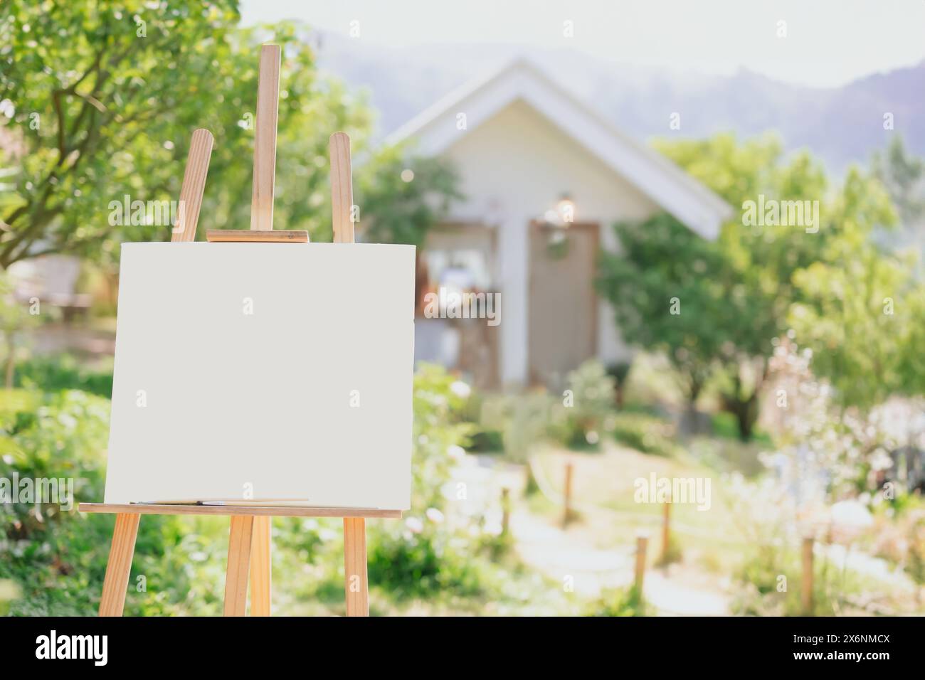 Painting canvas on wood stand outdoor with blur green nature house ...