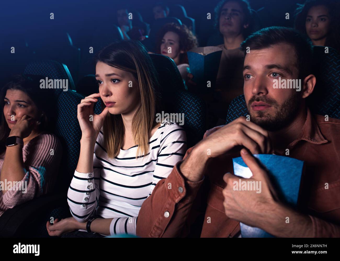 Group of people watching sad movie in cinema Stock Photo - Alamy