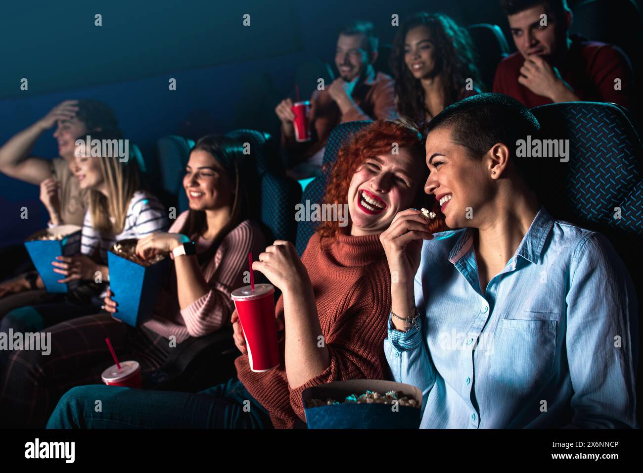 Group of cheerful people laughing while watching movie in cinema Stock ...