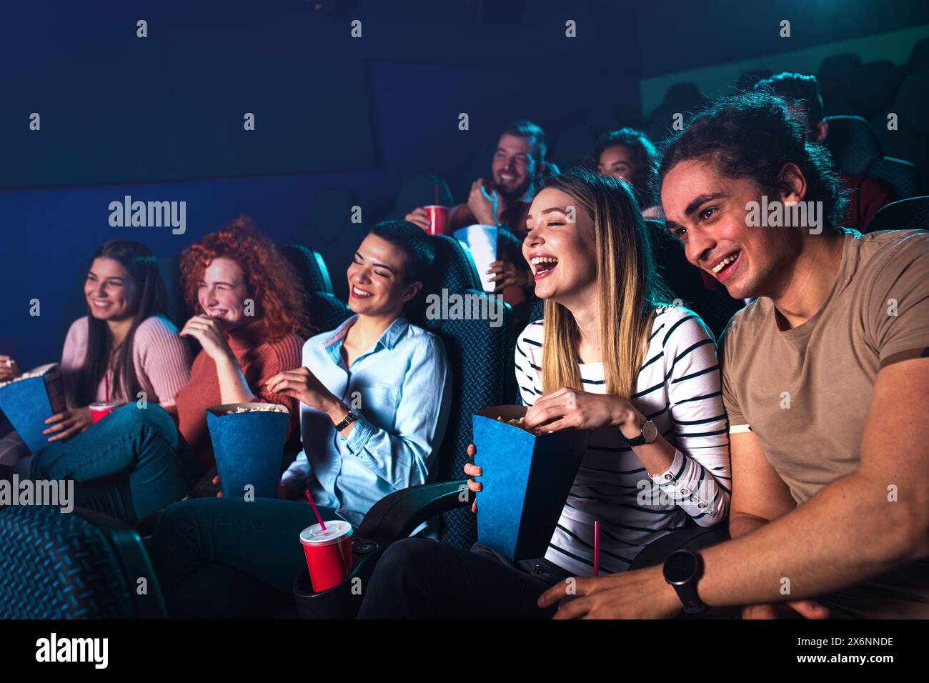 Group of cheerful people laughing while watching movie in cinema Stock ...