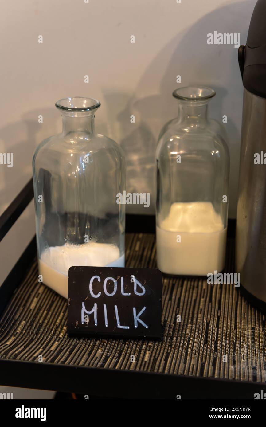 Fresh, cold milk ready to pour from classic liter size clear, glass ...