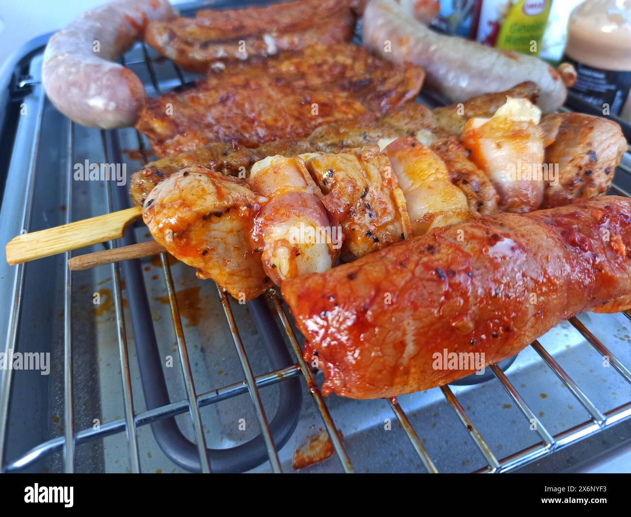 Grillgut auf einem Tischgrill im eigenen Garten. Grillsaison 2024 ...
