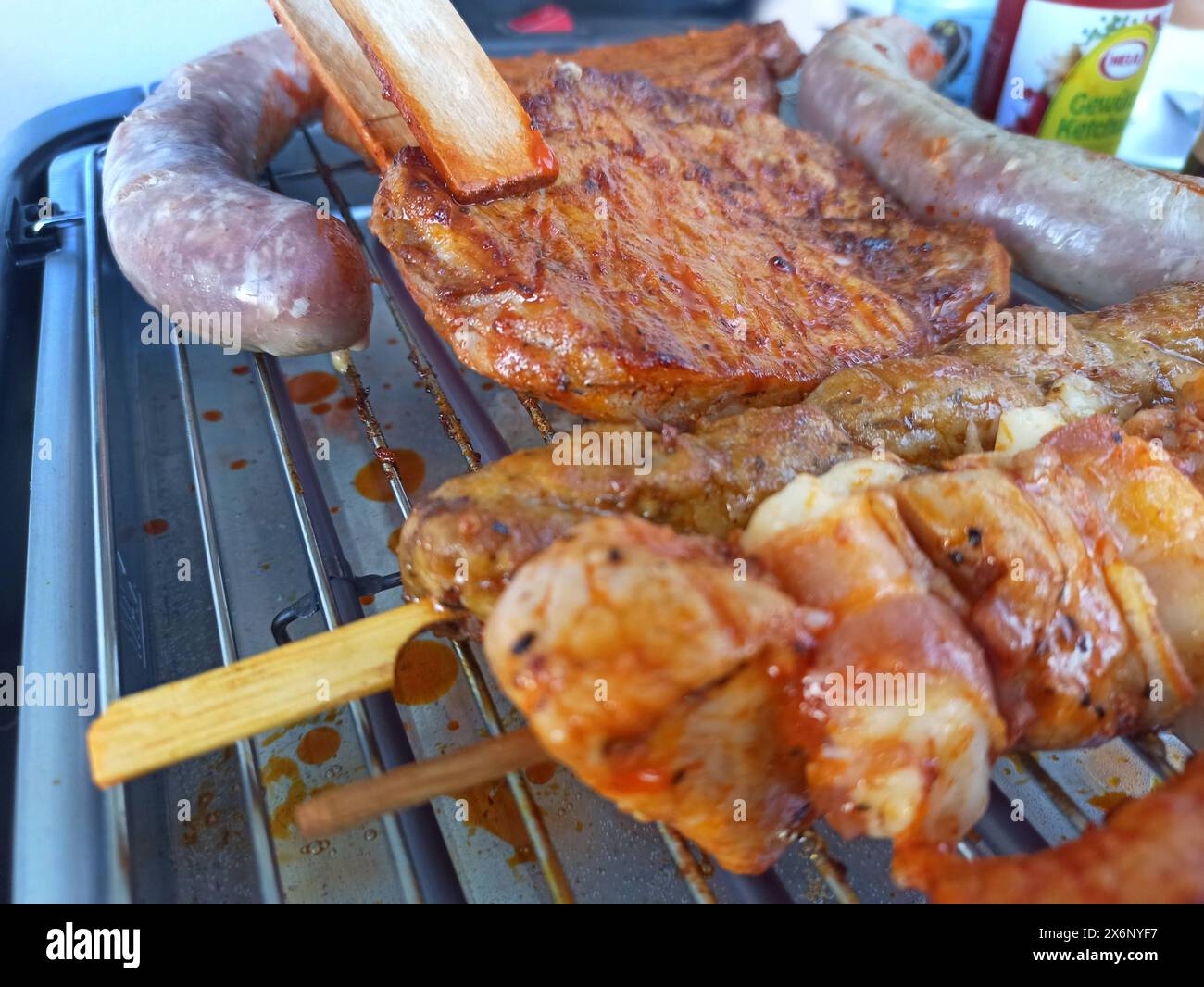 Grillgut auf einem Tischgrill im eigenen Garten. Grillsaison 2024 ...