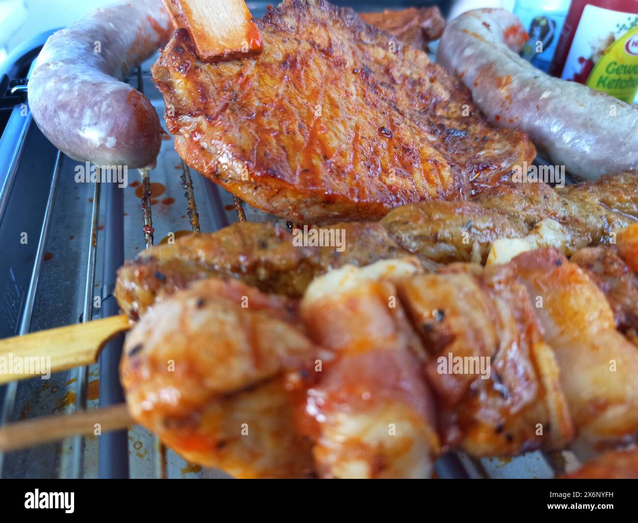 Grillgut auf einem Tischgrill im eigenen Garten. Grillsaison 2024 ...