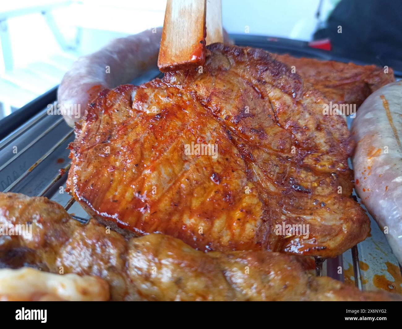 Grillgut auf einem Tischgrill im eigenen Garten. Grillsaison 2024 ...