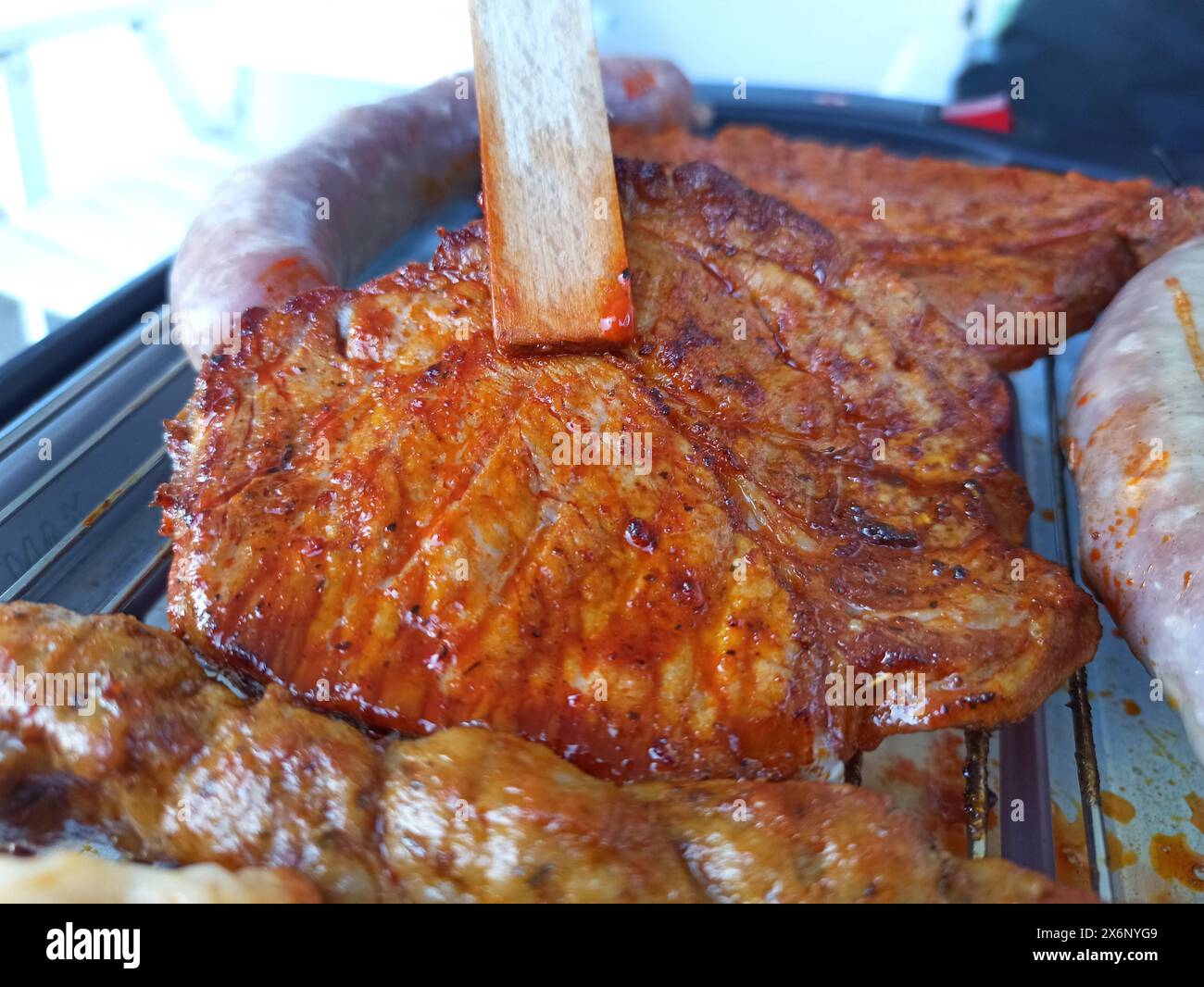 Grillgut auf einem Tischgrill im eigenen Garten. Grillsaison 2024 ...