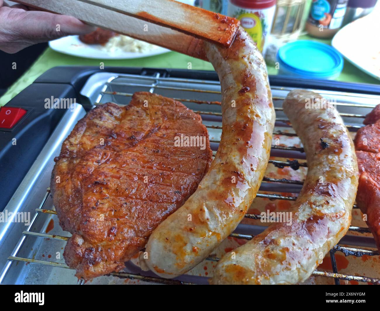 Grillgut auf einem Tischgrill im eigenen Garten. Grillsaison 2024 ...